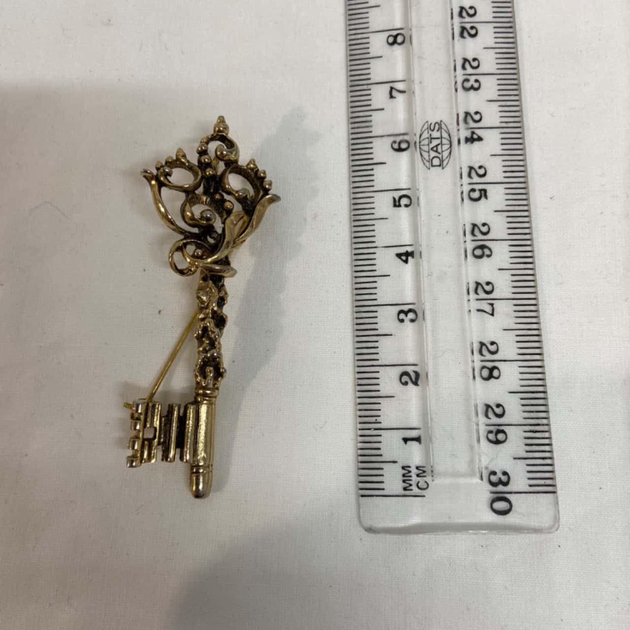Gold key brooch (s)