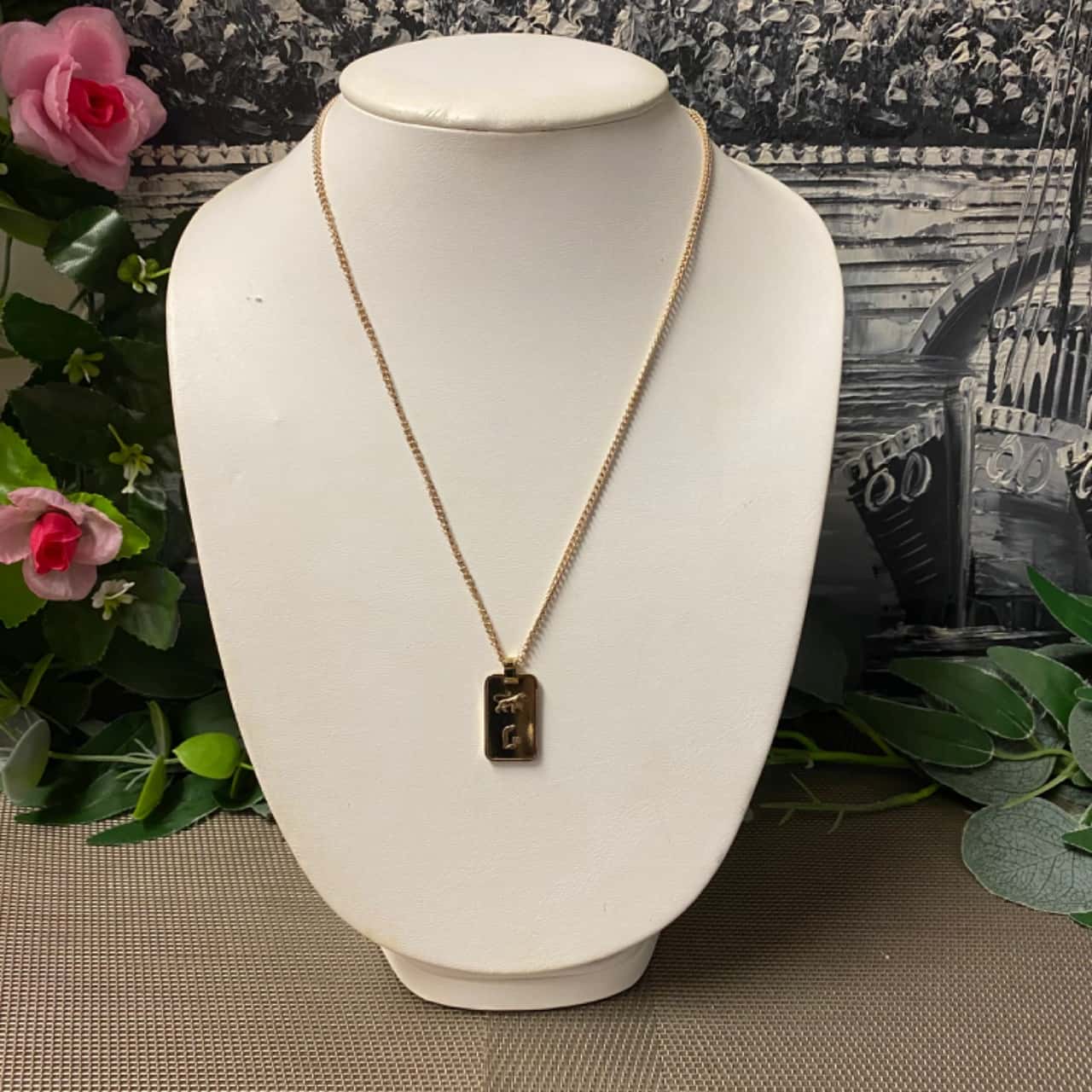 Gold tone long chain Leo pendant necklace (s)